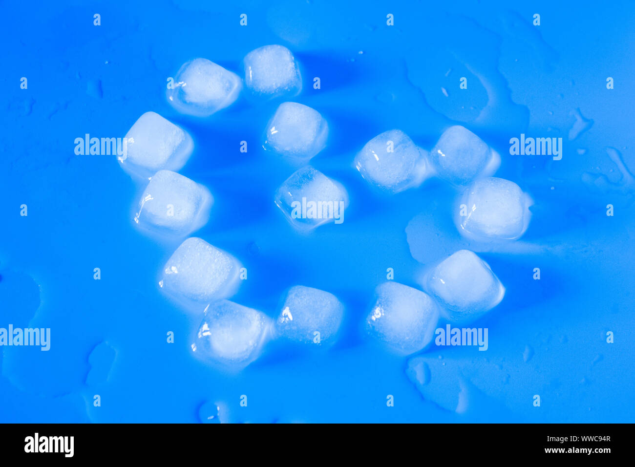 Melting ice cubes background on blue background Stock Photo - Alamy