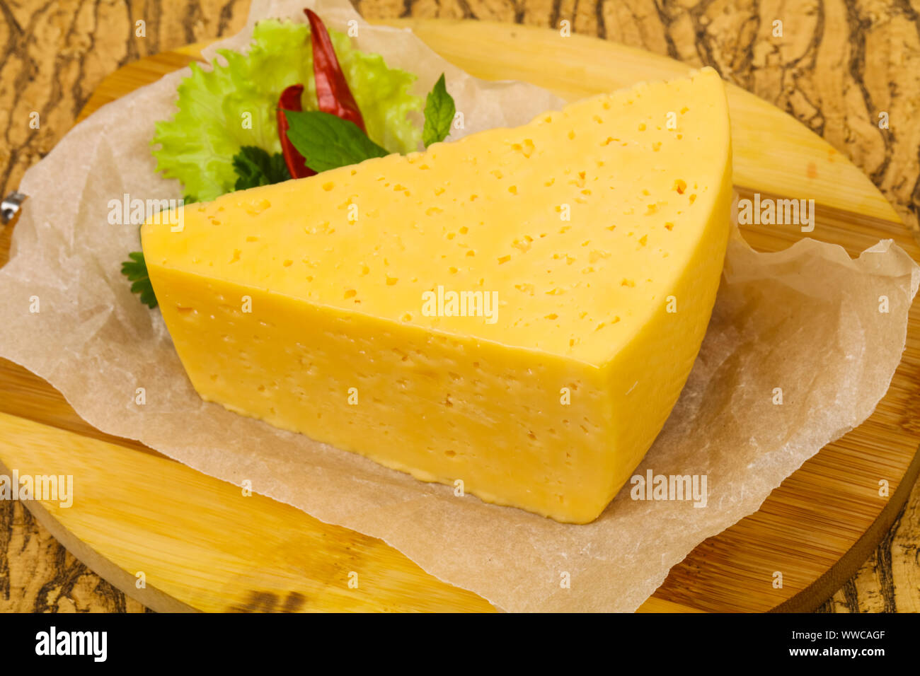 Piece. of Yellow Cheese served herbs Stock Photo - Alamy