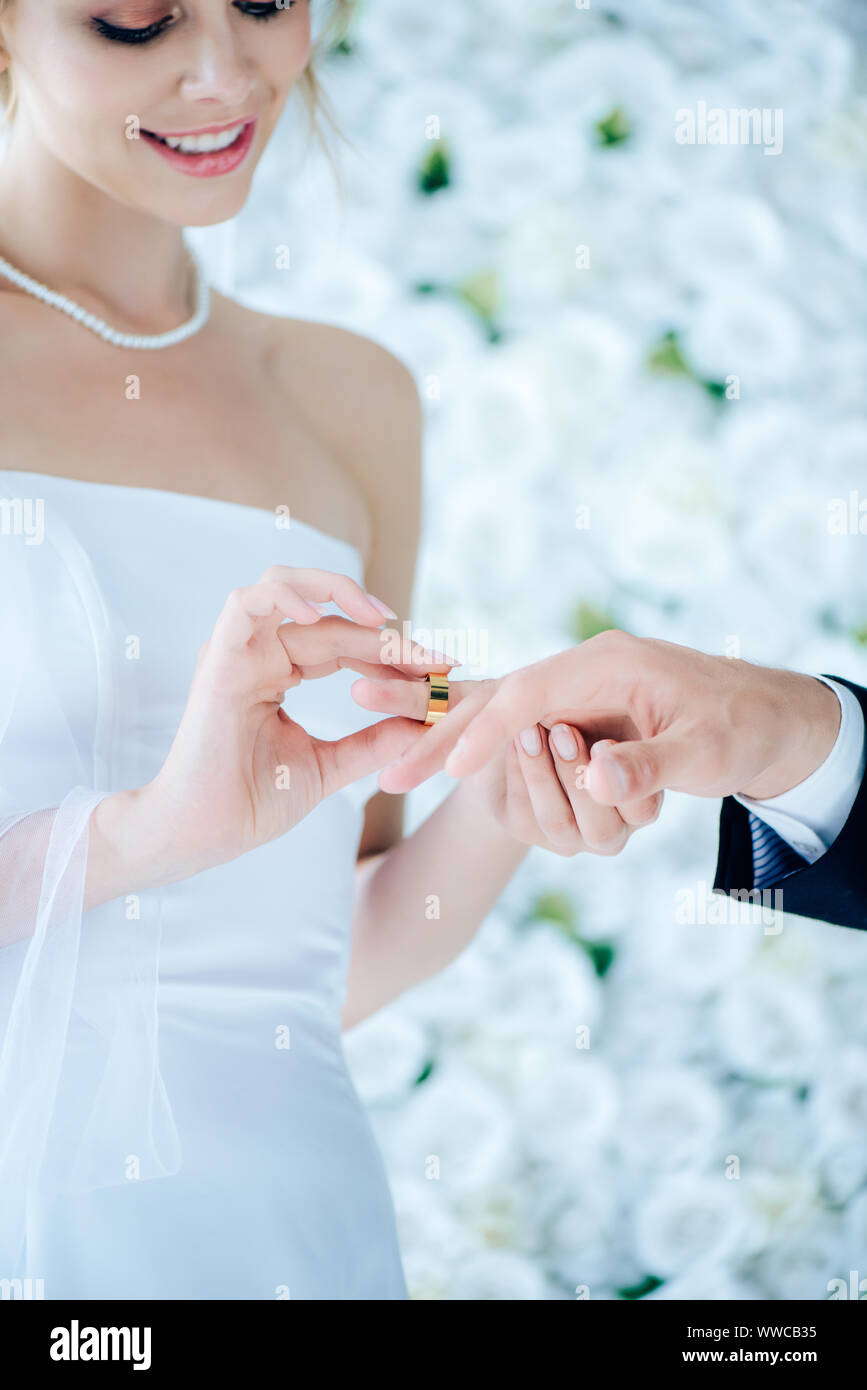attractive and smiling bride putting wedding ring on finger Stock Photo ...