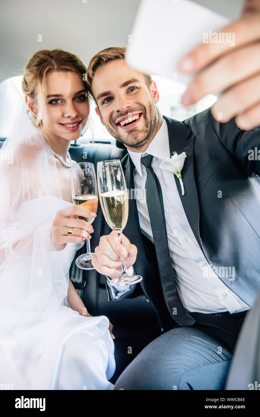 attractive bride and handsome bridegroom taking selfie in car Stock ...