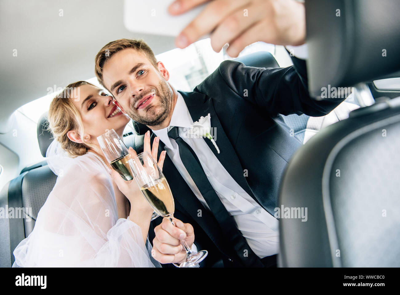 attractive bride and handsome bridegroom taking selfie in car Stock ...