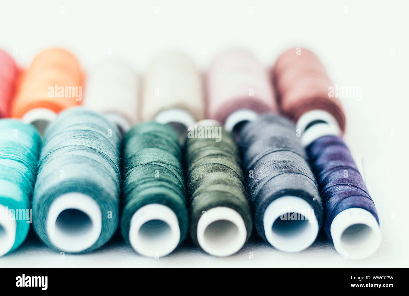 Colored sewing thread coils on white background with copy space for ...