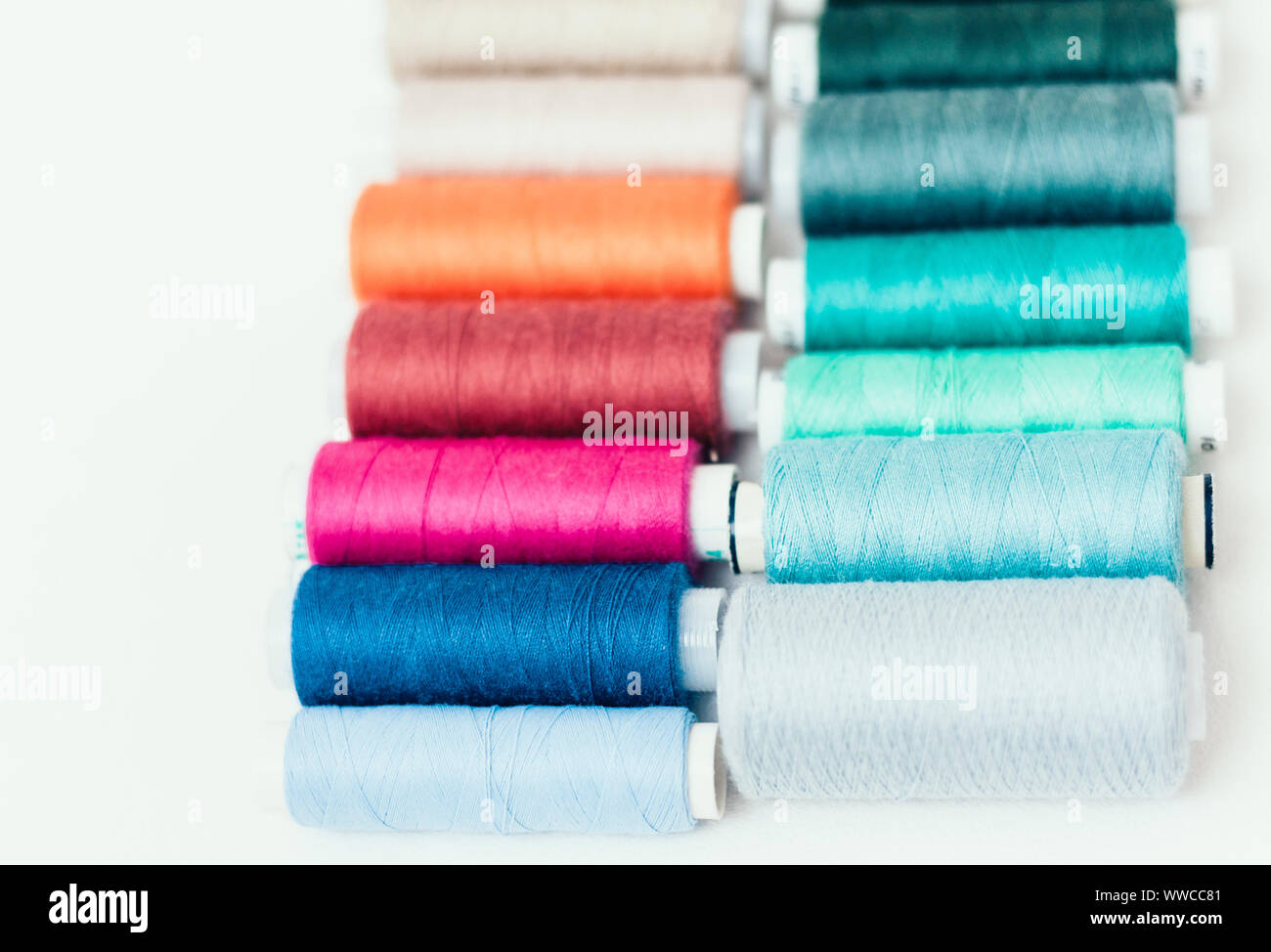 Colored sewing thread coils on white background with copy space for ...