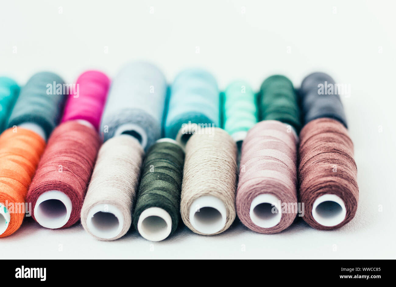 Colored sewing thread coils on white background with copy space for ...