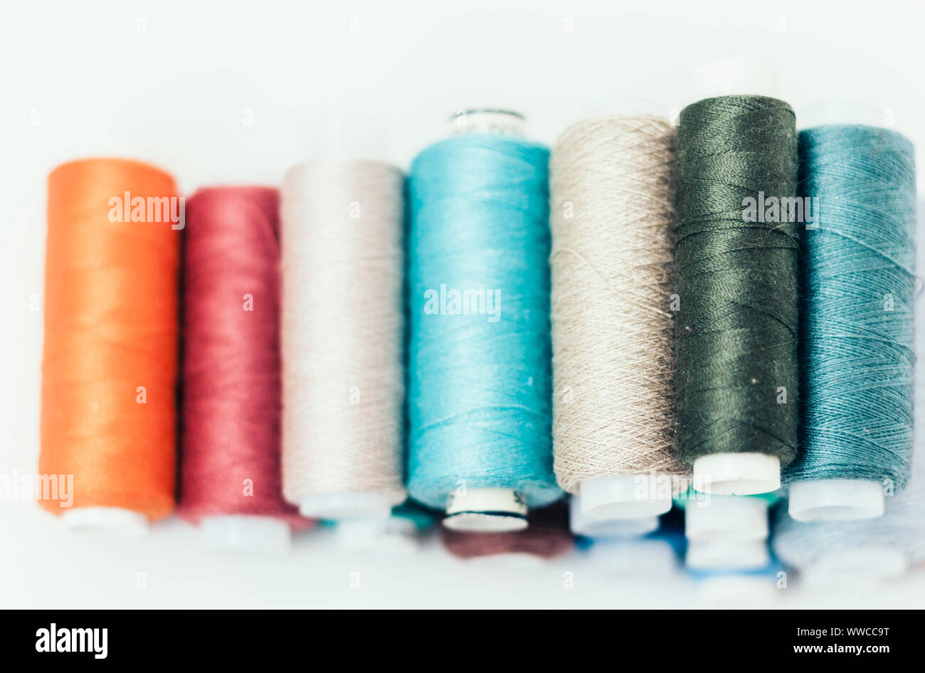 Colored sewing thread coils on white background with copy space for ...