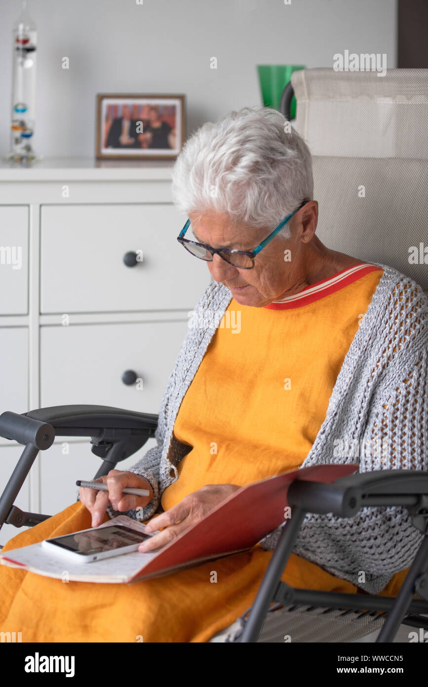 An elderly person uses a mobile phone by reading notes Stock Photo - Alamy