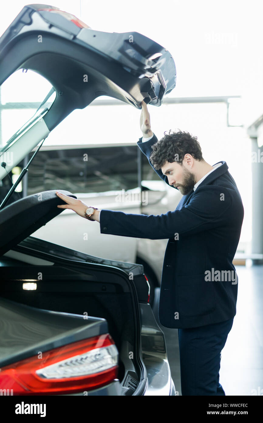 It is so roomy inside. Handsome young car salesman showing the car ...