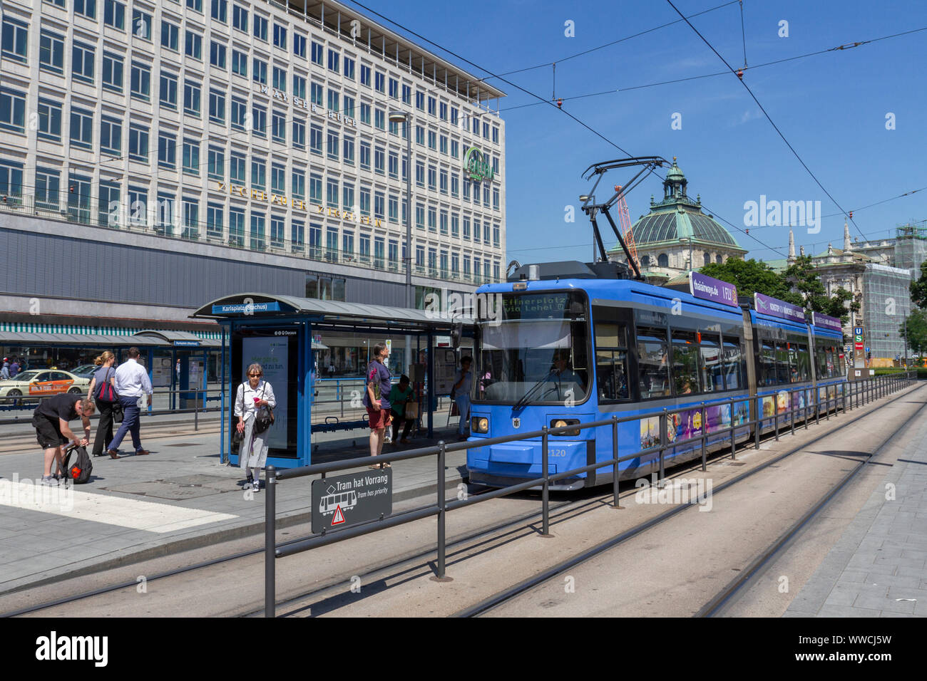 A public tram pulling up to a tram stop near Karlsplatz in Munich ...