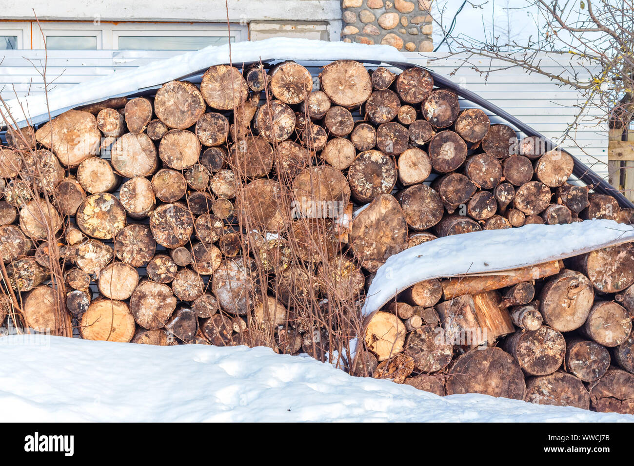 Pile of firewood under the snow in the winter Stock Photo - Alamy