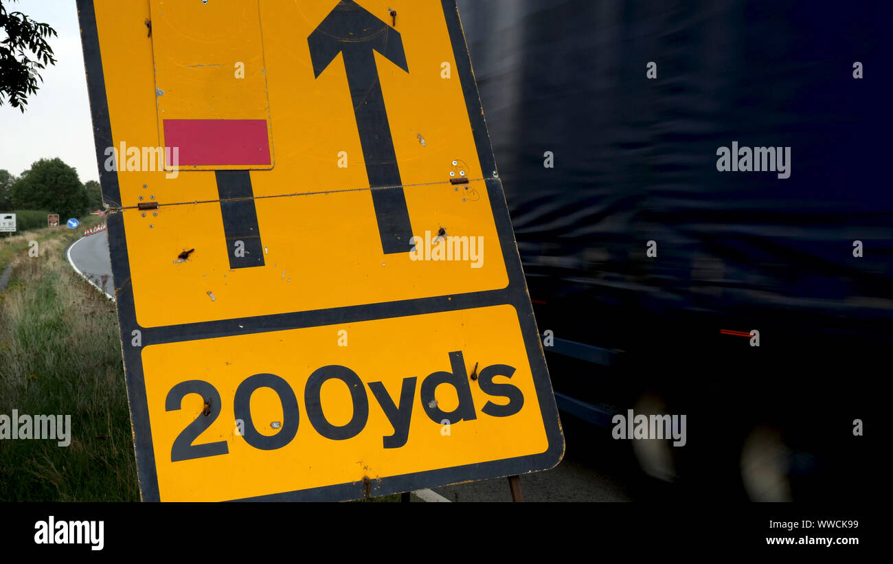 200 yards roadworks warning sign on UK motorway at evening with traffic ...