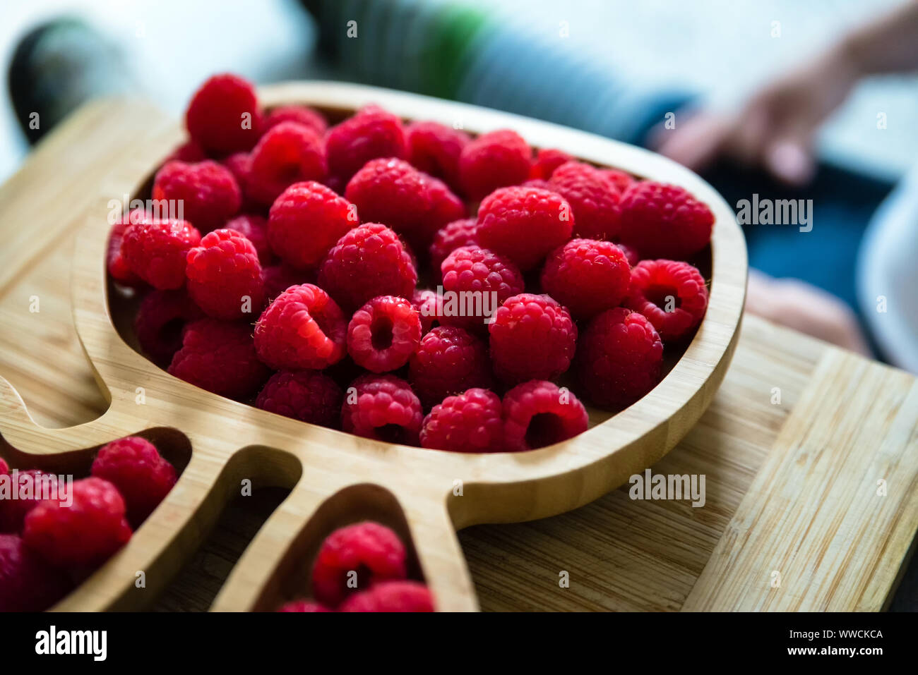 fresh raspberries next to baby boy sitting on sofa. baby exploring ...