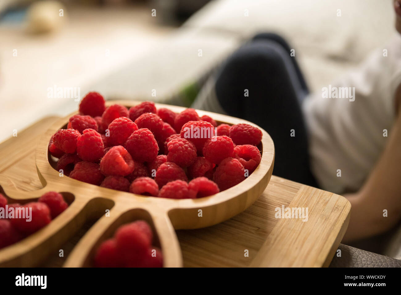 fresh raspberries next to baby boy sitting on sofa. baby exploring ...