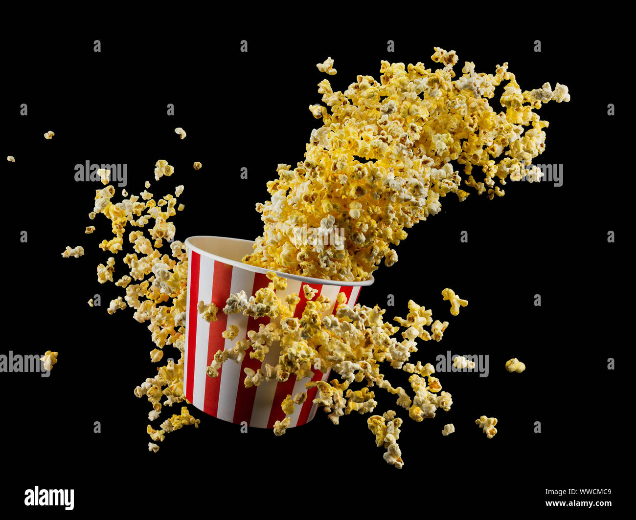 Flying popcorn from striped bucket isolated on black background Stock ...