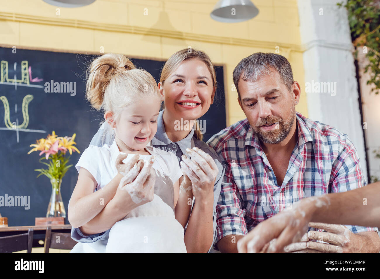 Happy family are sculpting from clay on a pottery wheel. Family of ...