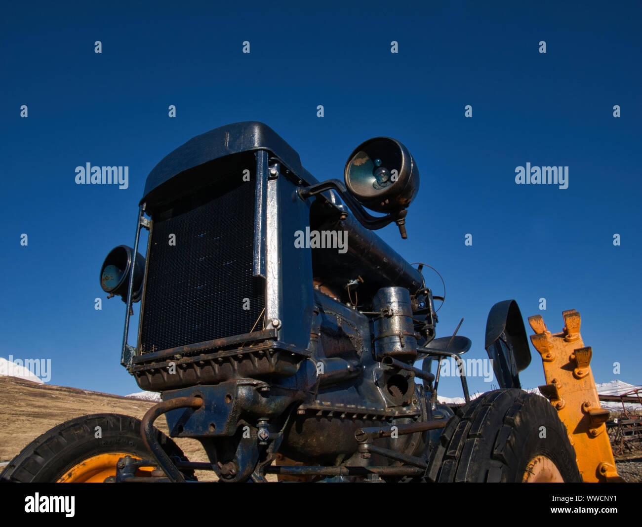 The radiator and the lights of an old blue vintage tractor Stock Photo ...