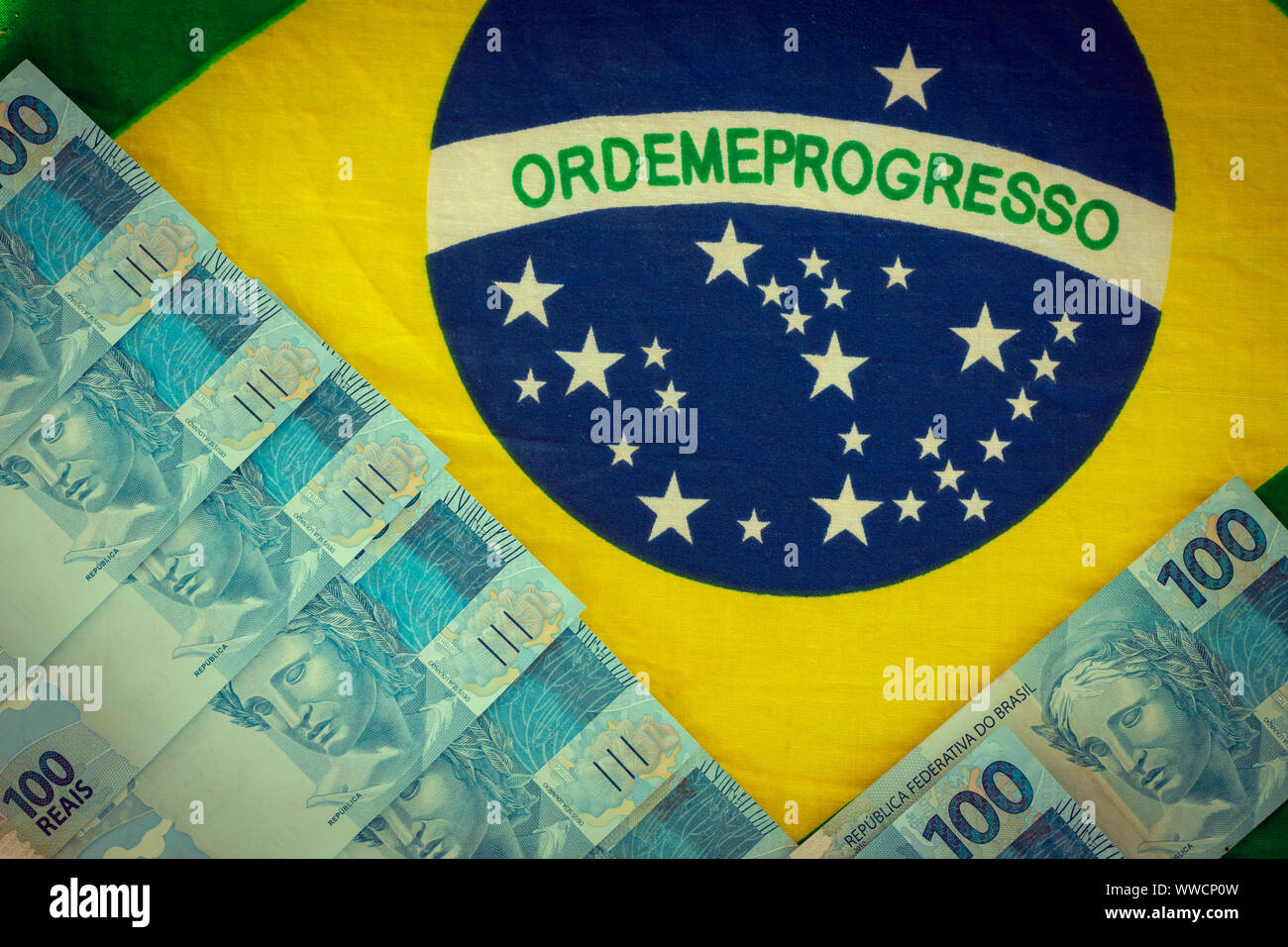 Brazilian Money 100 Reais Banknote With The National Flag Stock Photo brazilian-money-100-reais-banknote-with-the-national-flag-stock-photo