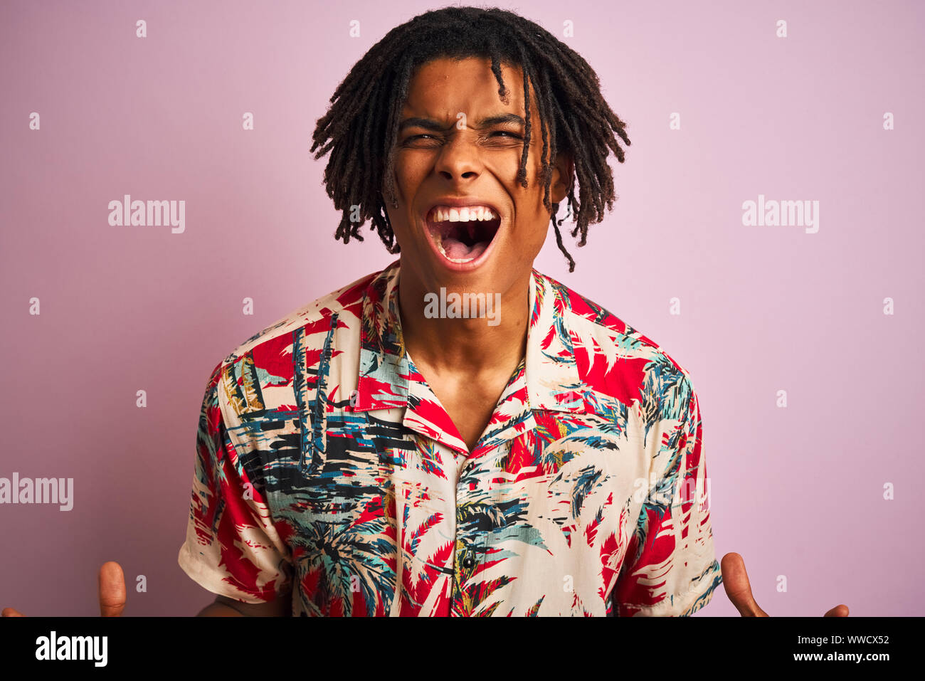 Afro man with dreadlocks on vacation wearing floral shirt over isolated ...
