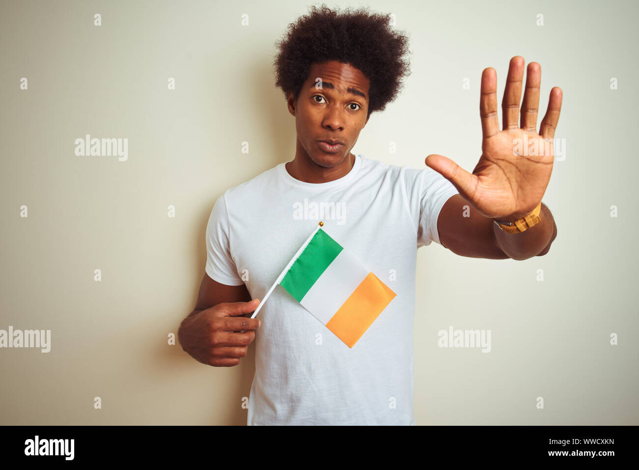 Young african american man holding Ireland Irish flag standing over ...