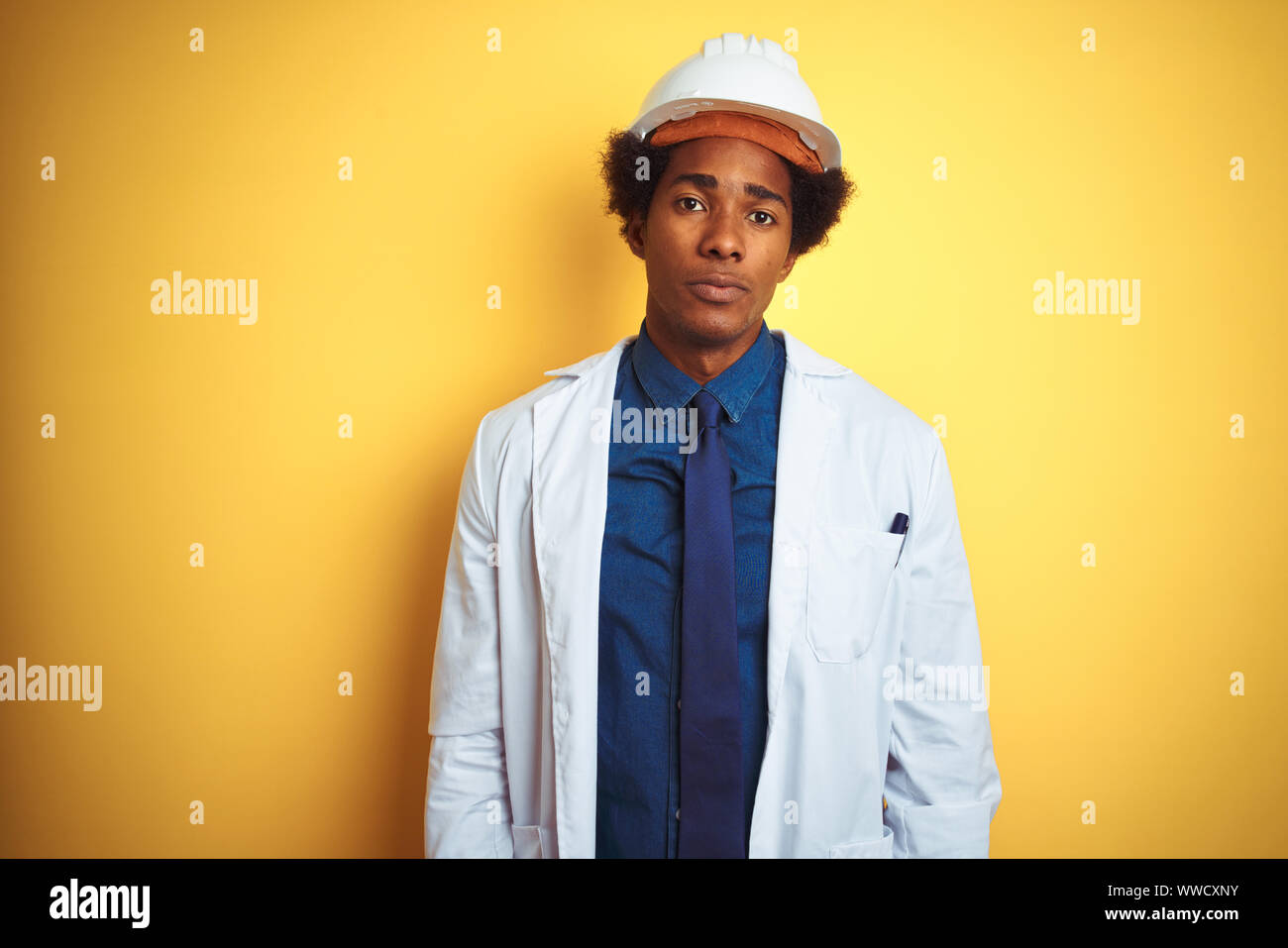 Afro american engineer man wearing white coat and helmet over isolated ...
