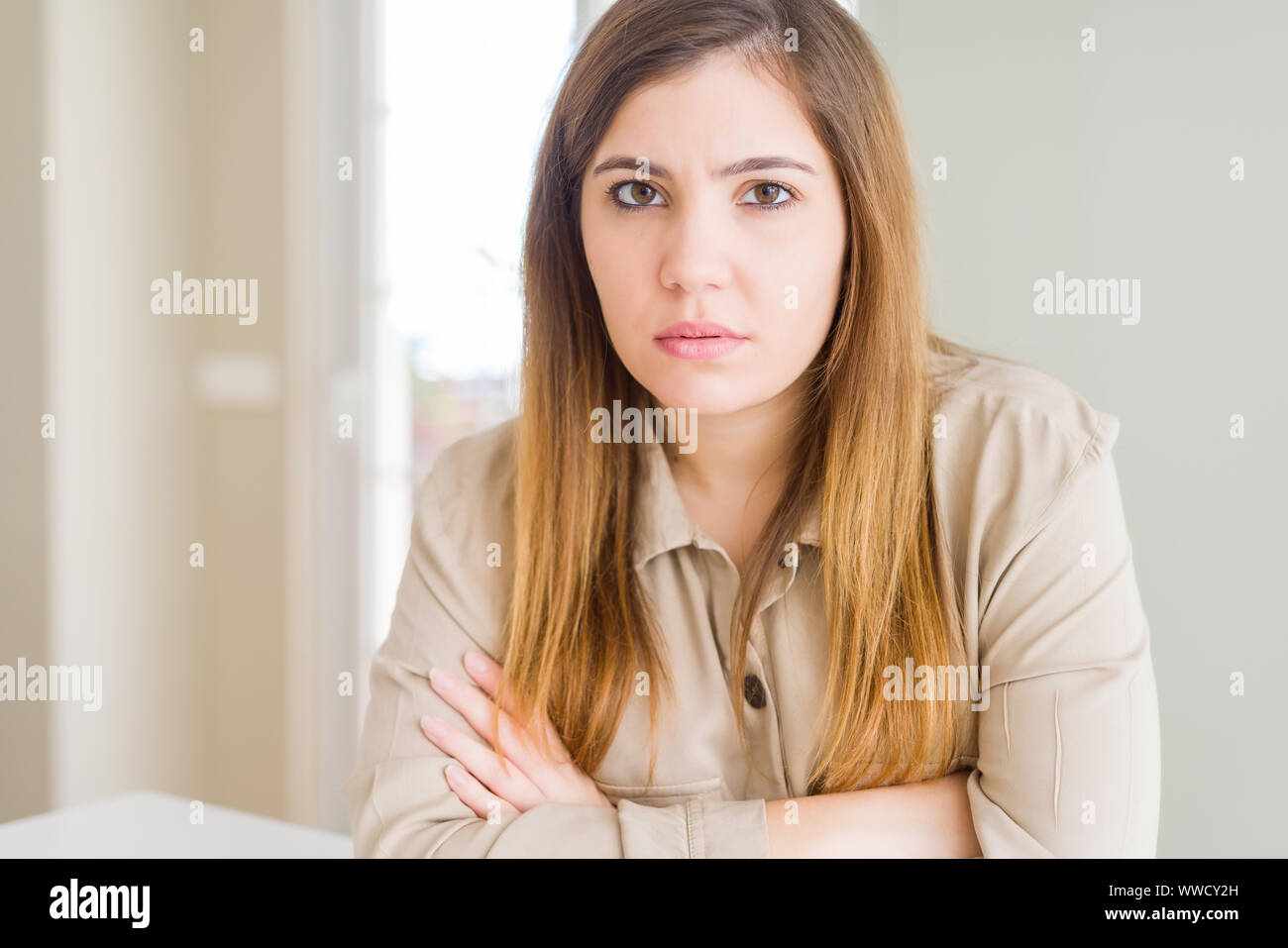 Beautiful young woman at home skeptic and nervous, disapproving ...