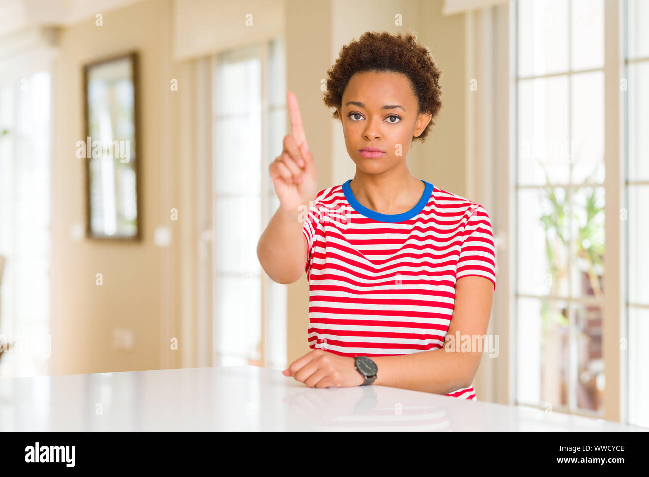 Young beautiful african american woman at home Pointing with finger up ...