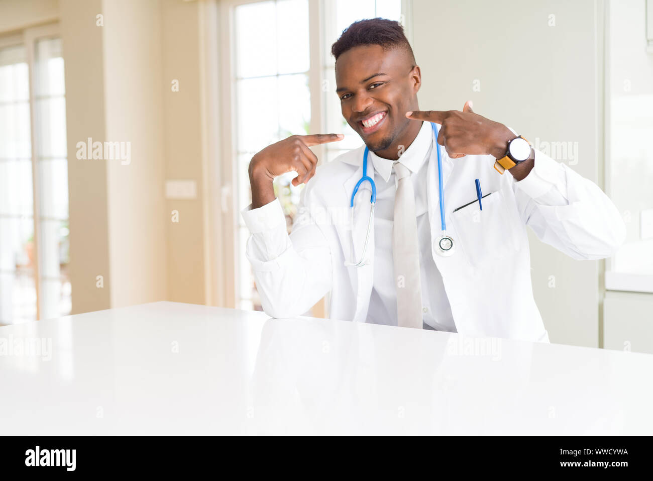 African american doctor man at the clinic smiling confident showing and ...