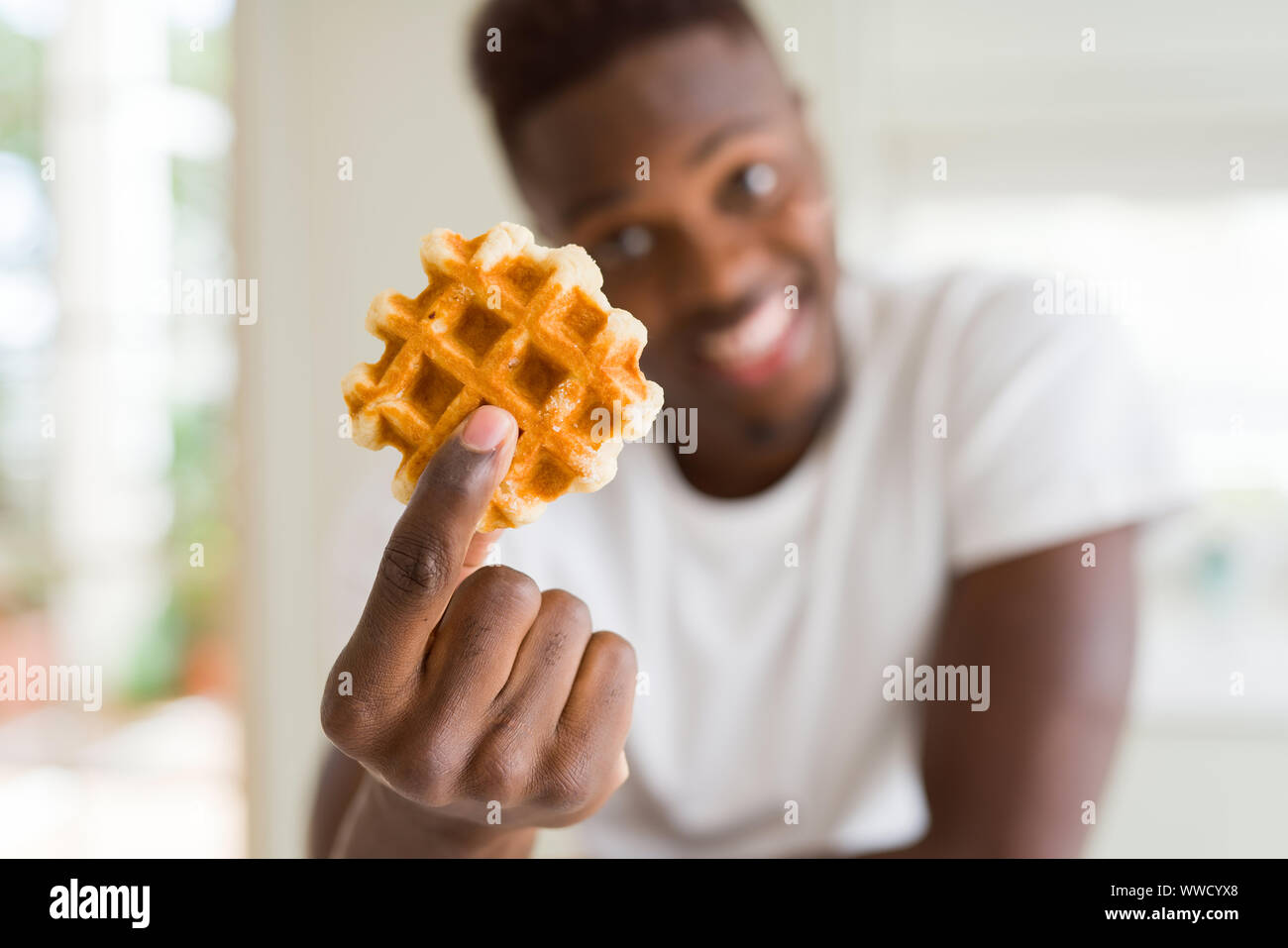 African american man eating sweet Belgian waffle with a happy face ...
