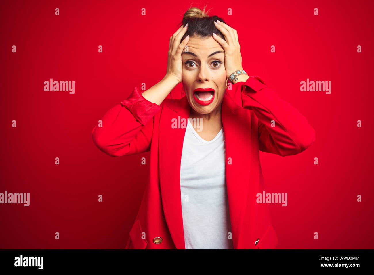 Young beautiful business woman standing over red isolated background ...