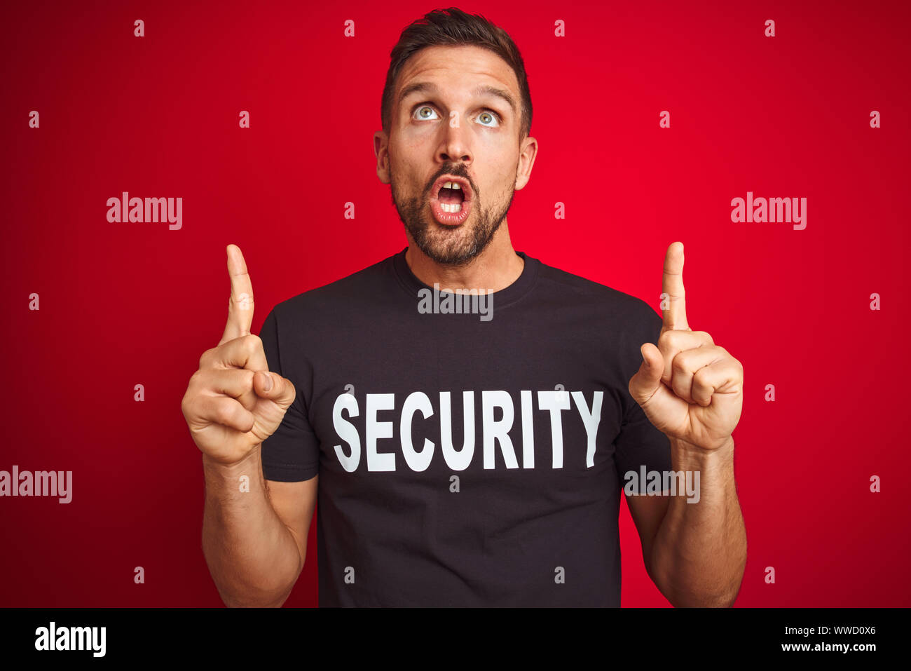 Young safeguard man wearing security uniform over red isolated ...