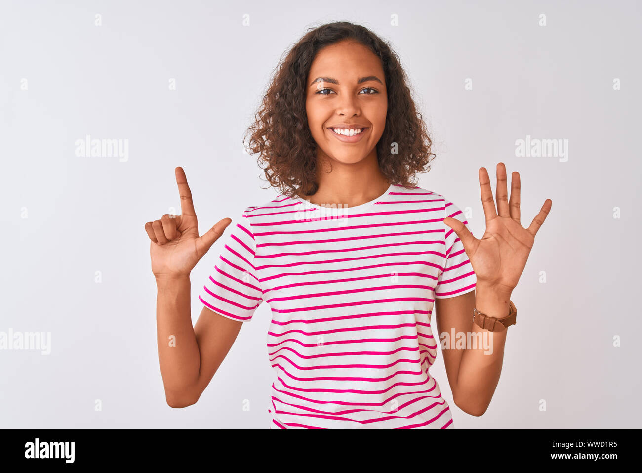 Young Brazilian Woman Wearing Pink Striped T Shirt Standing Over