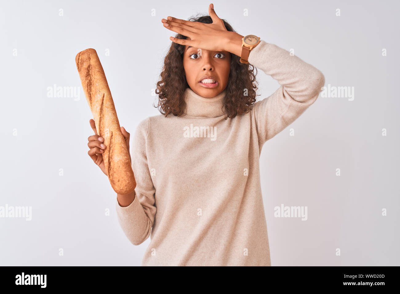 Young brazilian baker woman holding bread standing over isolated white ...
