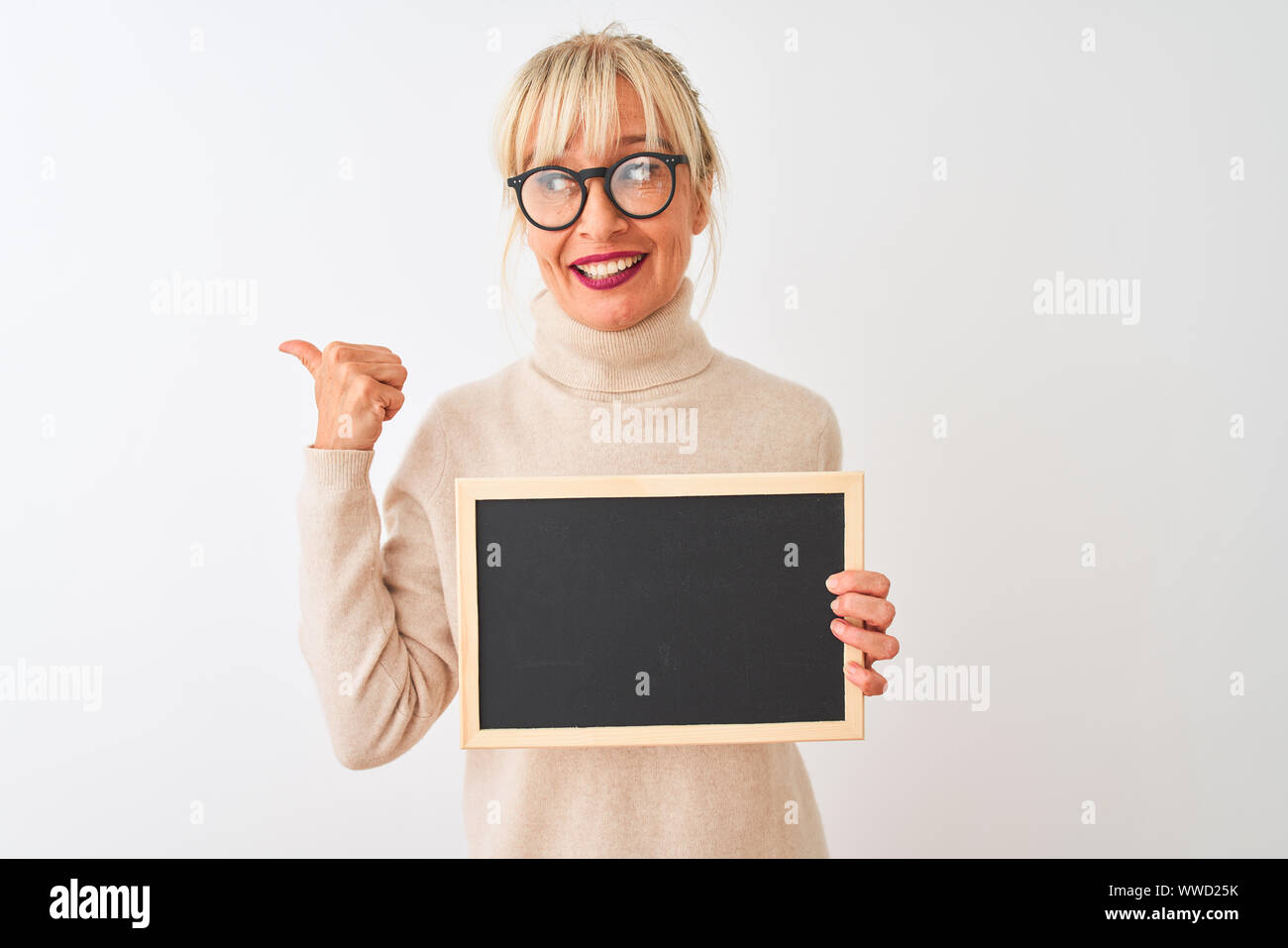 Middle age woman wearing glasses holding blackboard over isolated white ...