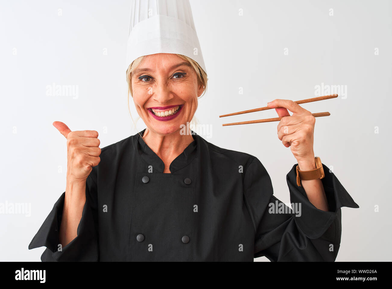 Middle age chef woman wearing cap holding chopsticks over isolated ...