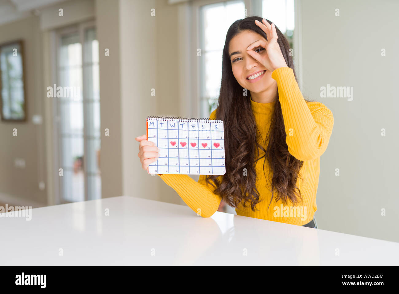 Young woman holding menstruation calendar with happy face smiling doing ...