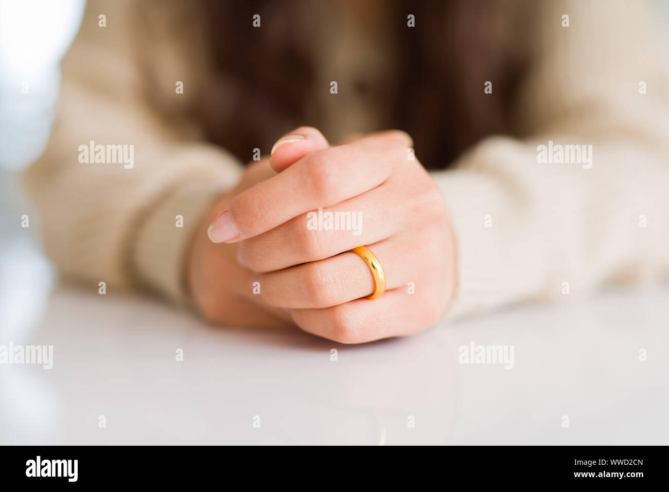 Close up of woman crossed hands wearing a golden alliance for marriage ...
