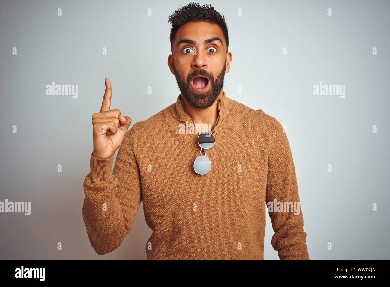 Indian man wearing elegant sweater and sunglasses standing over ...