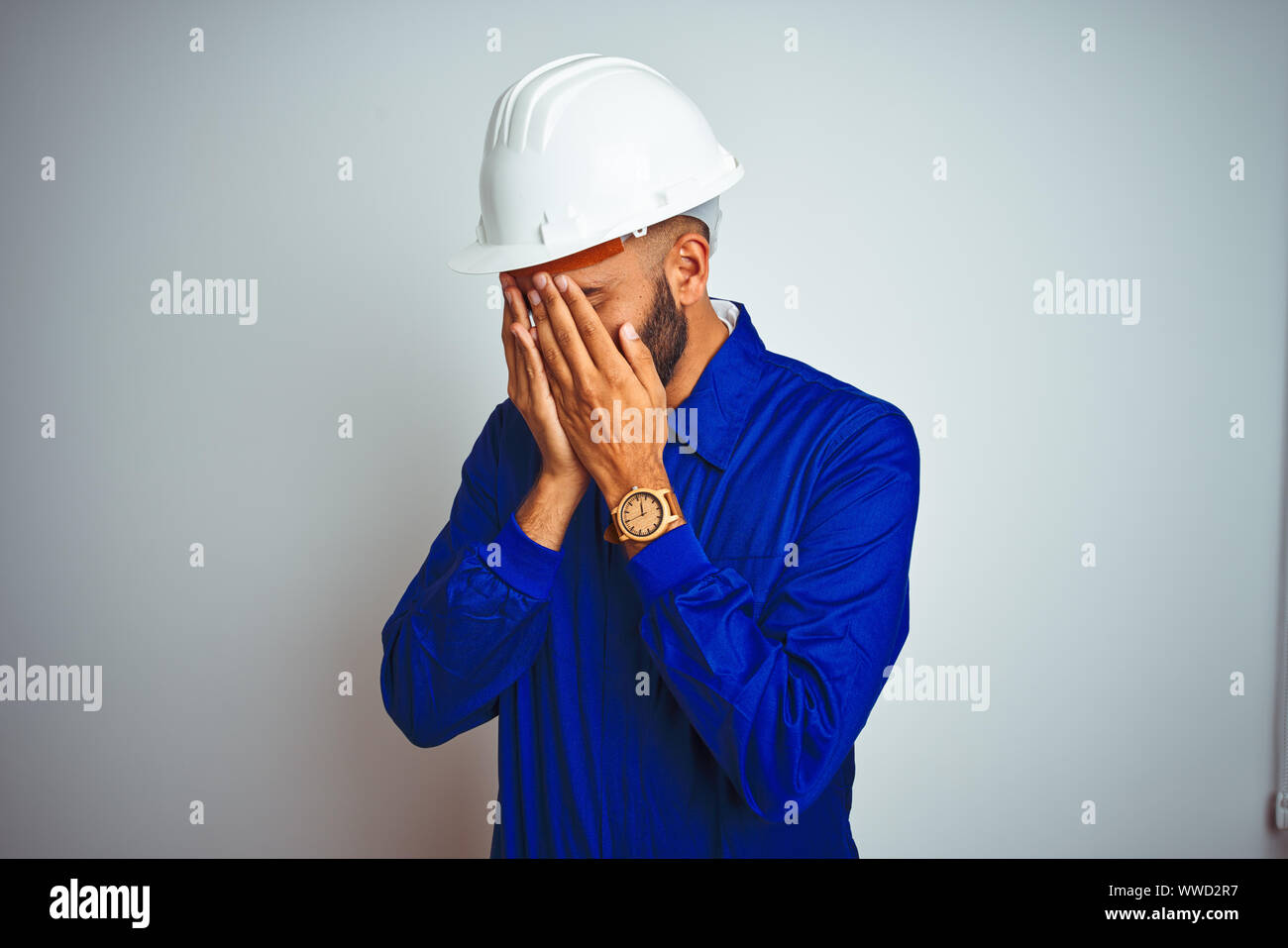 Handsome indian worker man wearing uniform and helmet over isolated ...