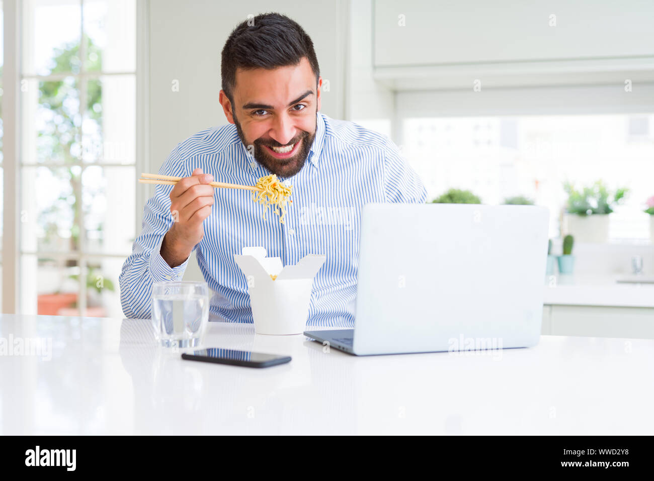 Business man eating asian food from delivery while working using ...