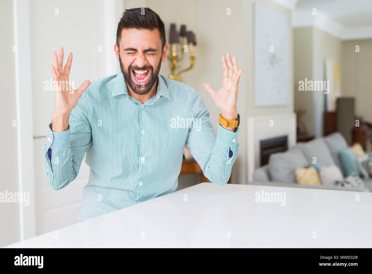 Handsome hispanic man at home celebrating mad and crazy for success ...