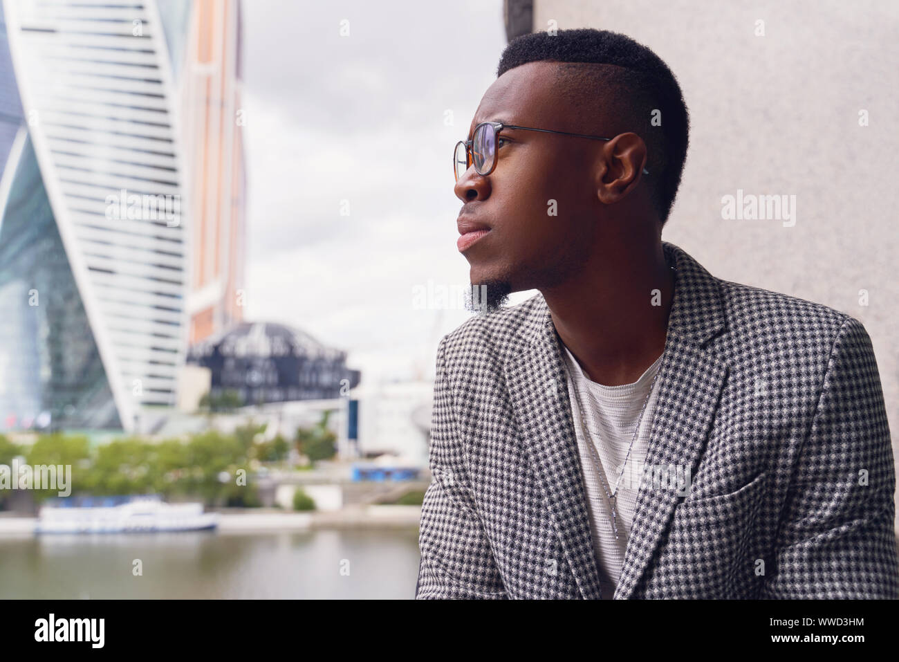 Young dark skinned man looking aside thoughtfully Stock Photo - Alamy