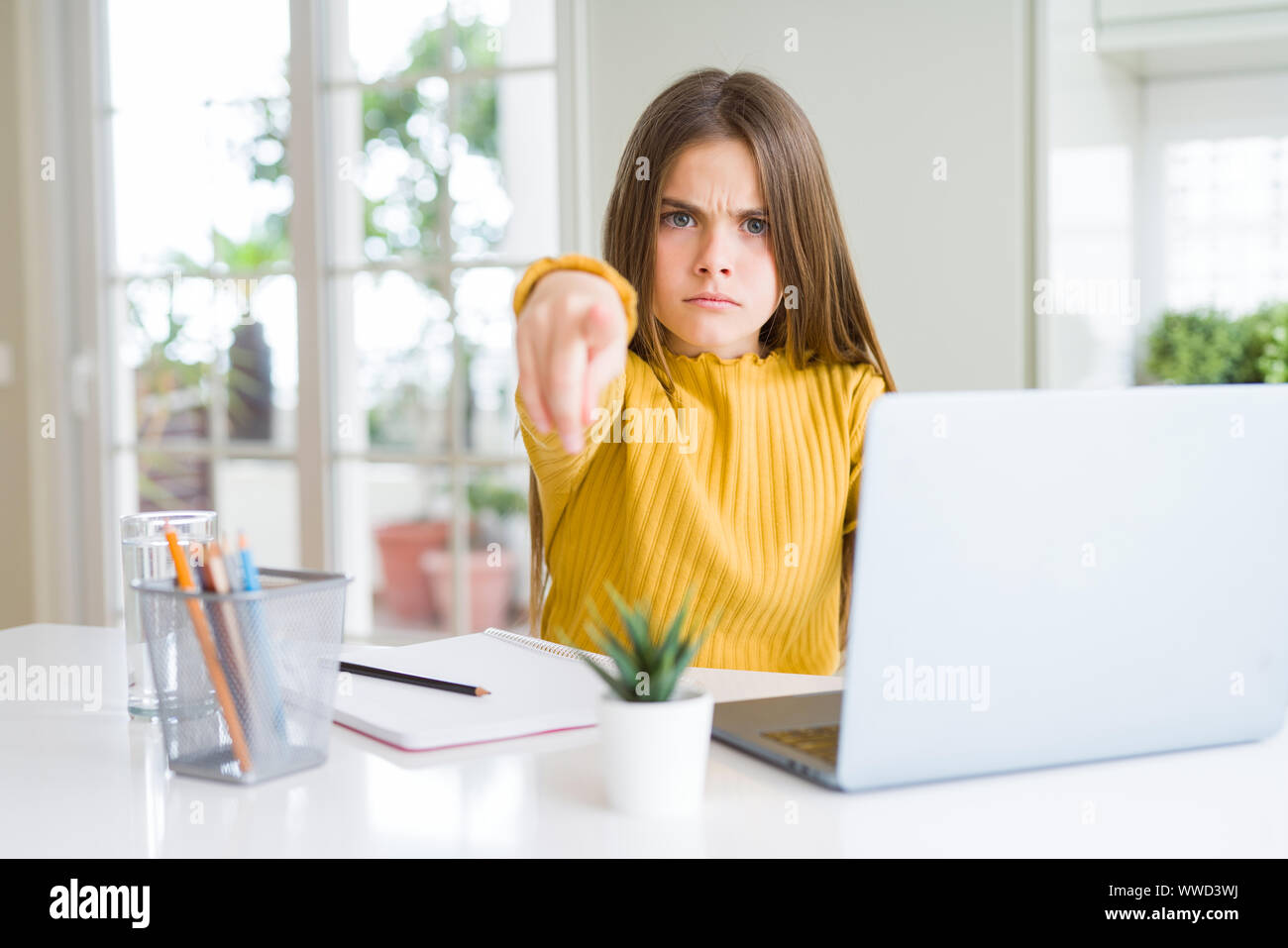Beautiful young girl studying for school using computer laptop pointing ...