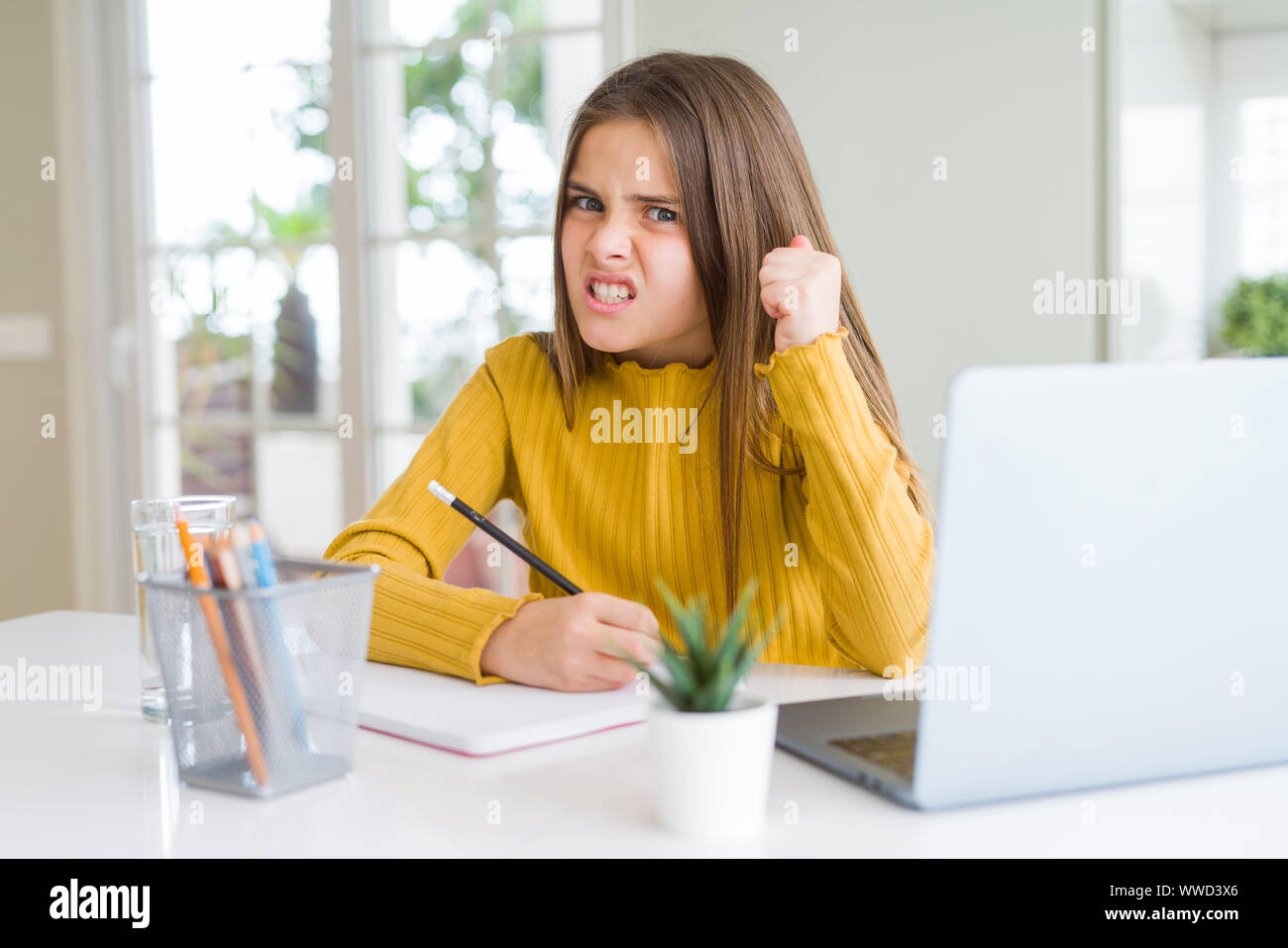 Beautiful young girl studying using computer laptop and writing on ...