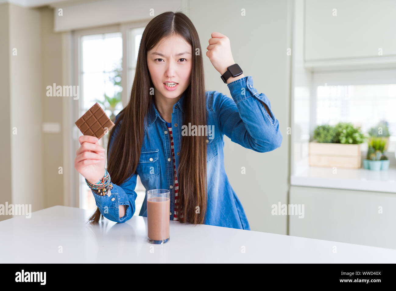 Beautiful Asian woman drinking chocolate milkshake and holding ...