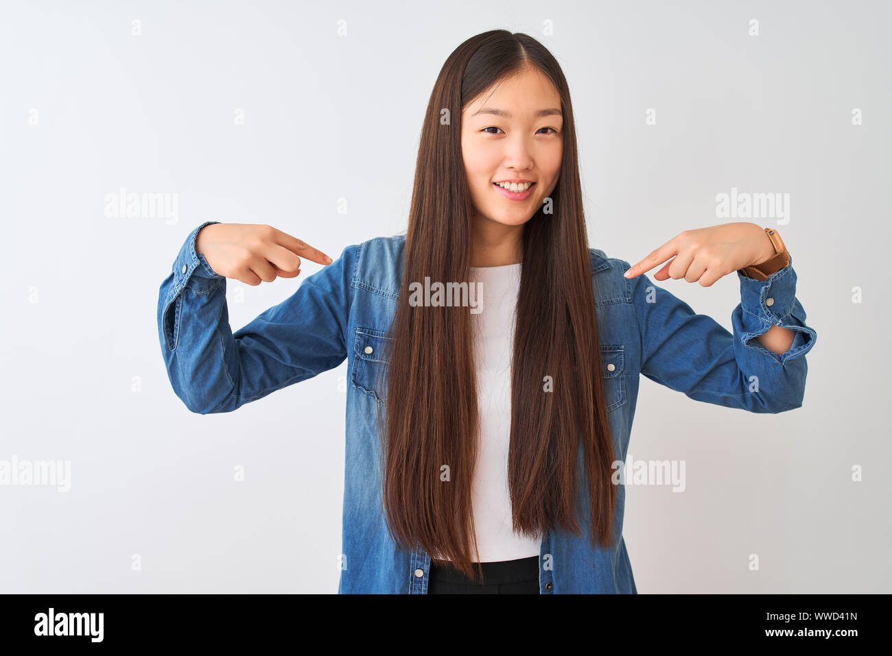 Young chinese woman wearing denim shirt standing over isolated white ...