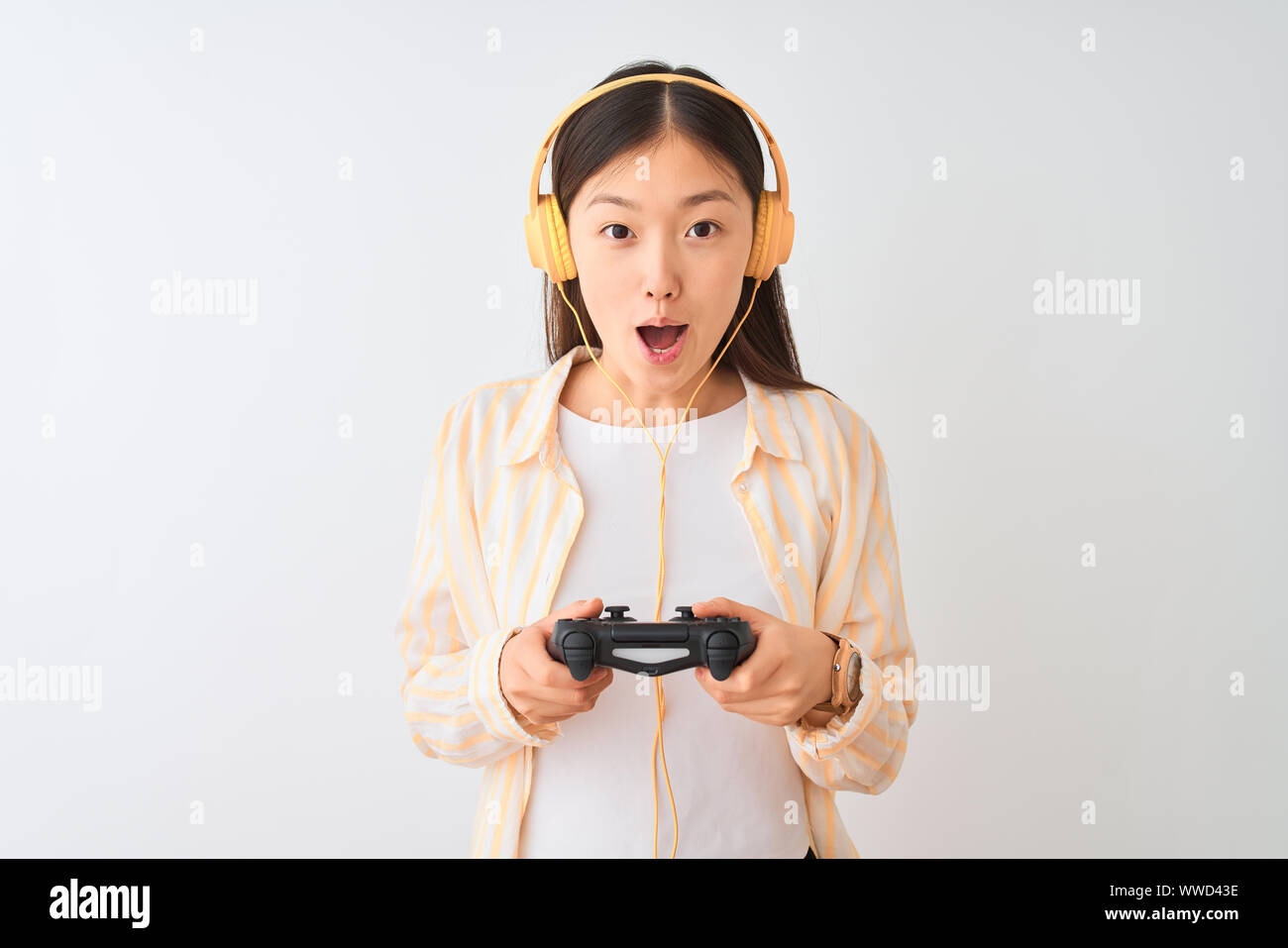 Chinese gamer woman playing video game using headphones over isolated ...
