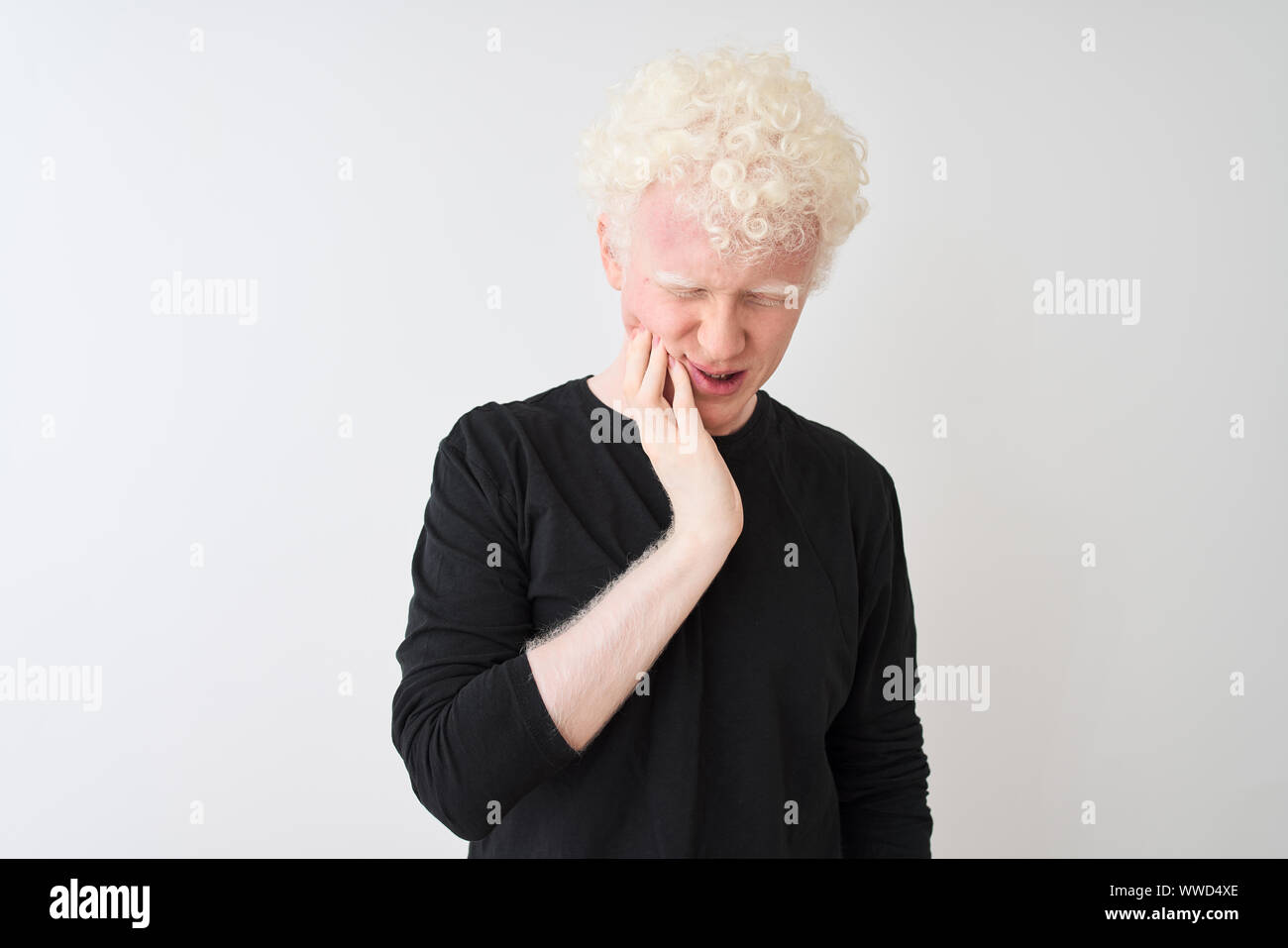 Young albino blond man wearing black t-shirt standing over isolated ...