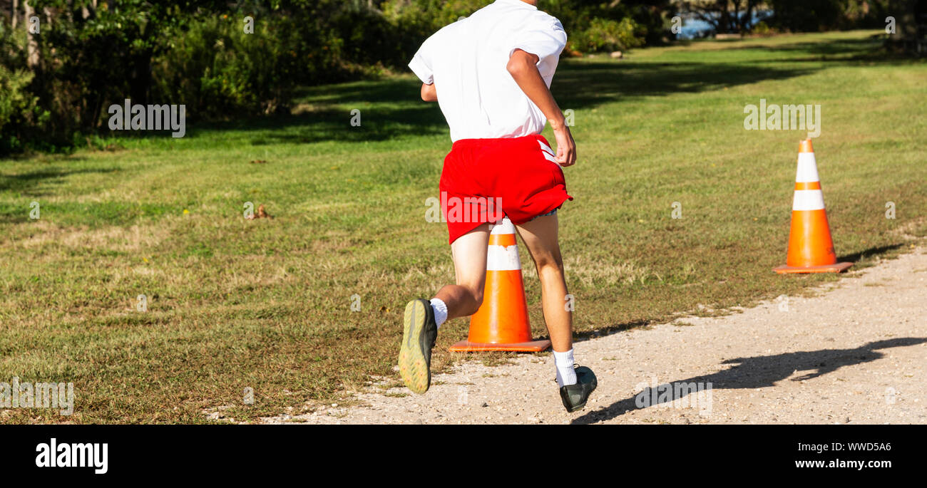 View from behind of a freshmen in high school is running a cross ...