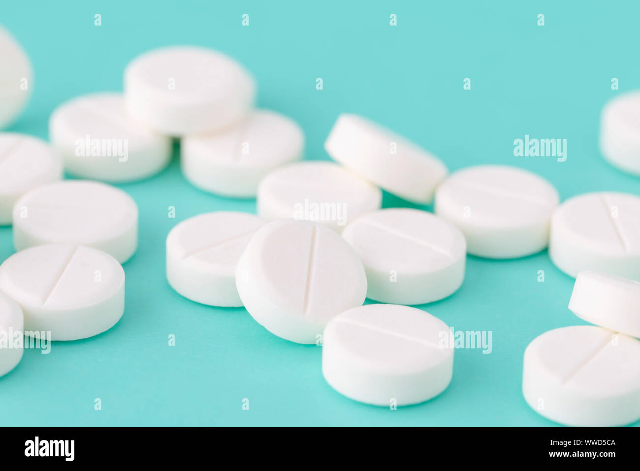 White round tablets close-up on a colored background Stock Photo - Alamy