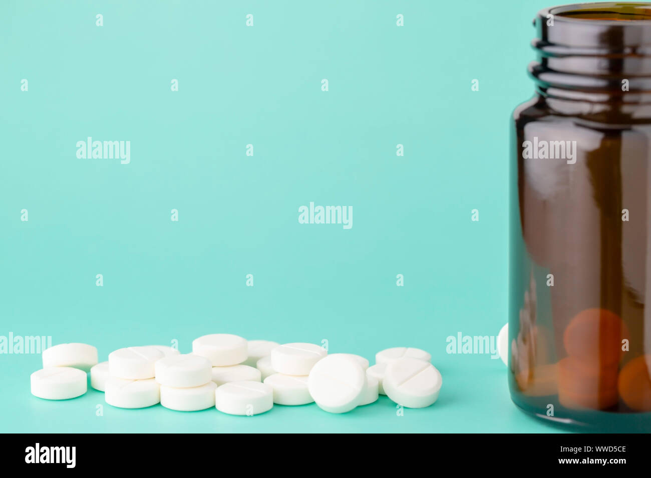 White round tablets scattered near glass bottle of pills Stock Photo ...