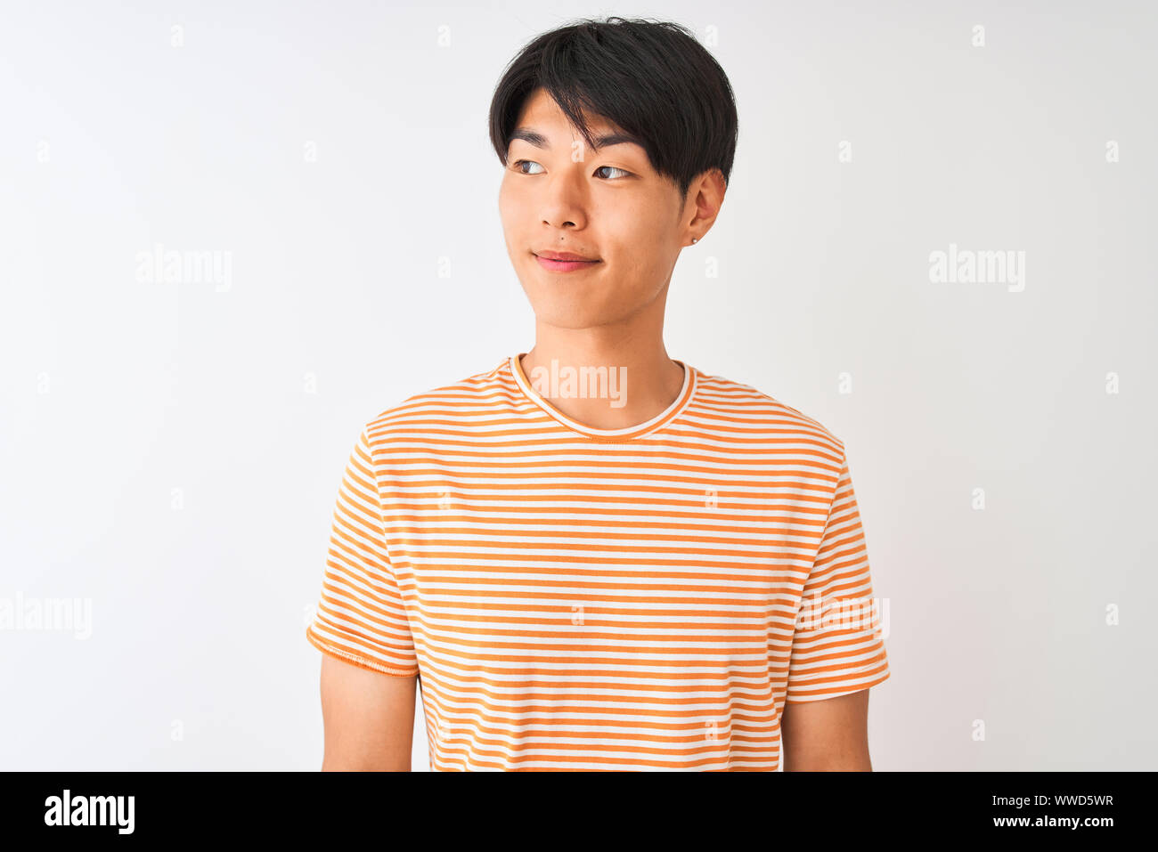 Young chinese man wearing casual striped t-shirt standing over isolated ...